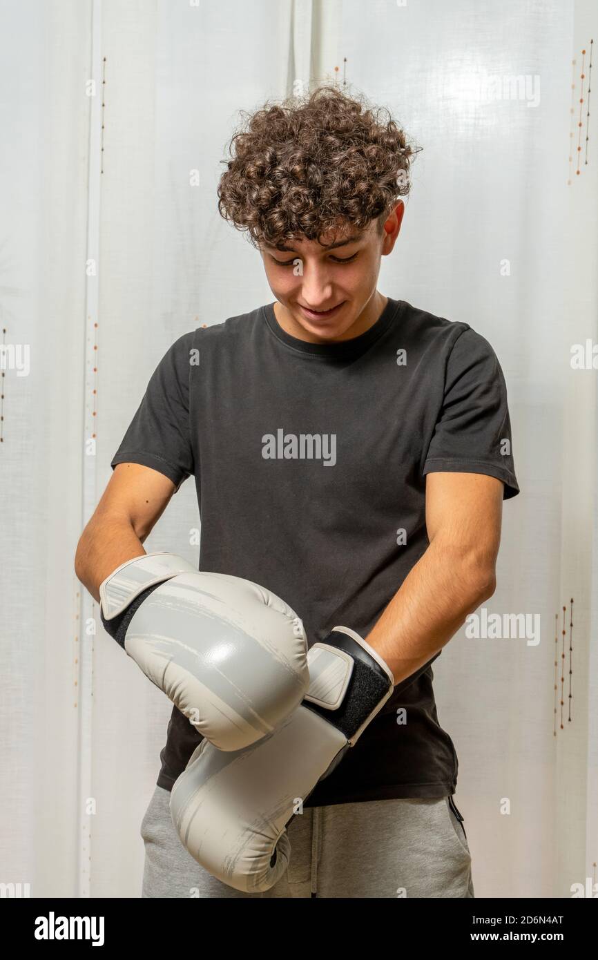 Attractive young man with curly hair wearing black t-shirt posing with ...