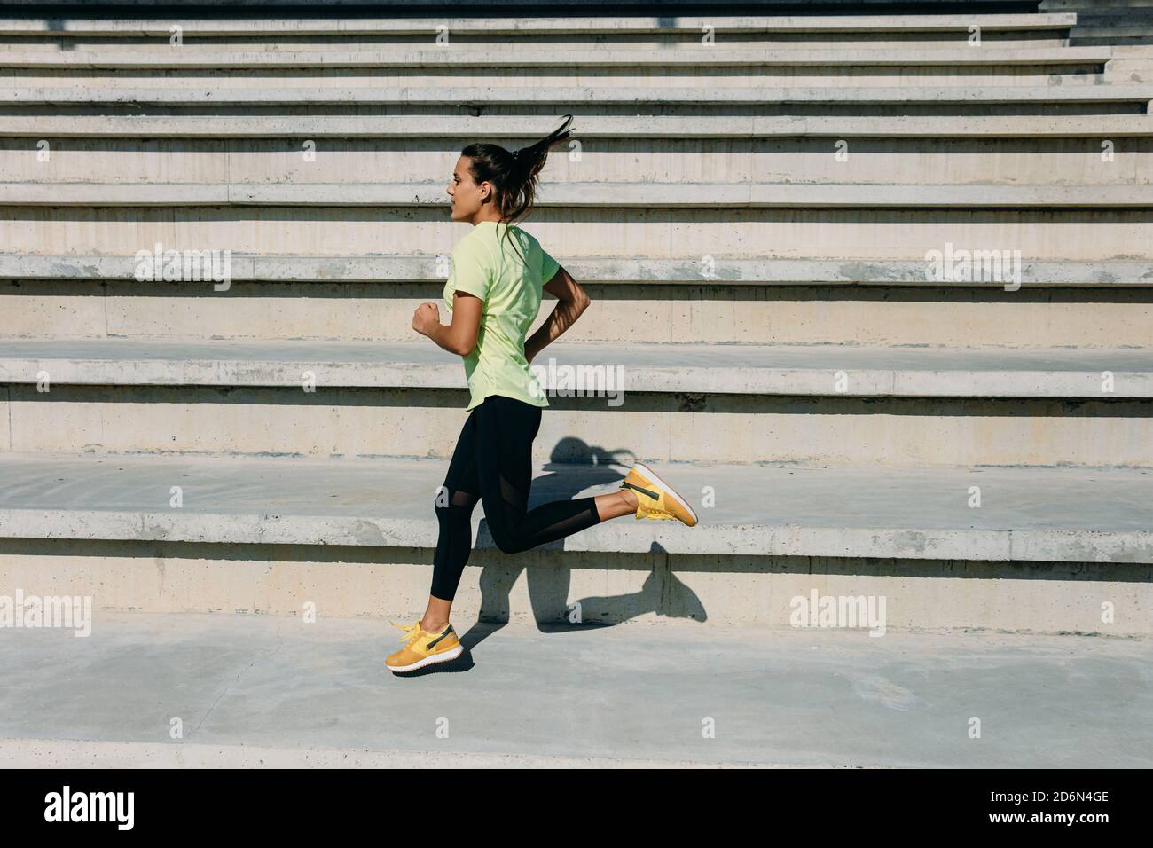 Strong female running at stadium during morning time Stock Photo - Alamy