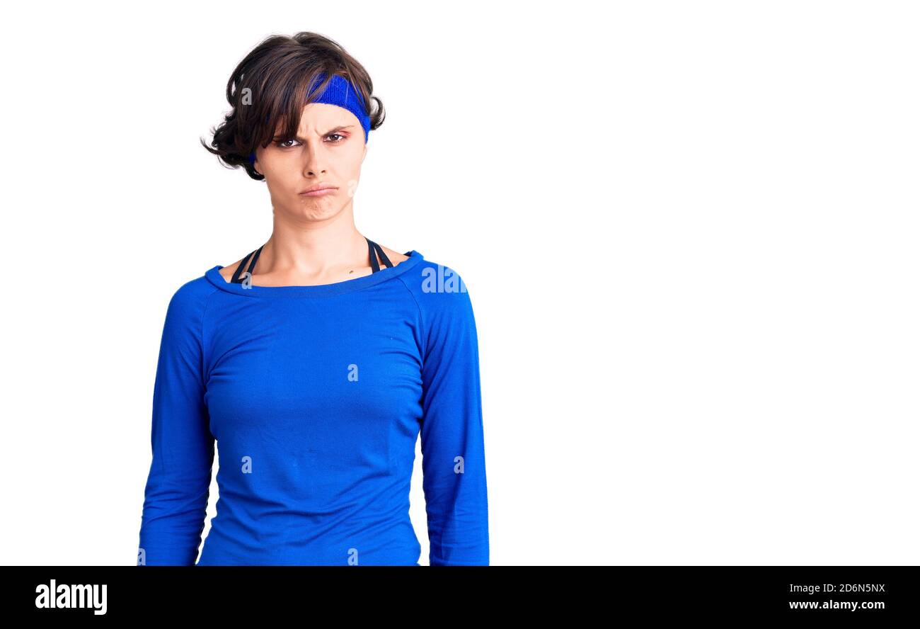 Beautiful young woman with short hair wearing training workout clothes ...