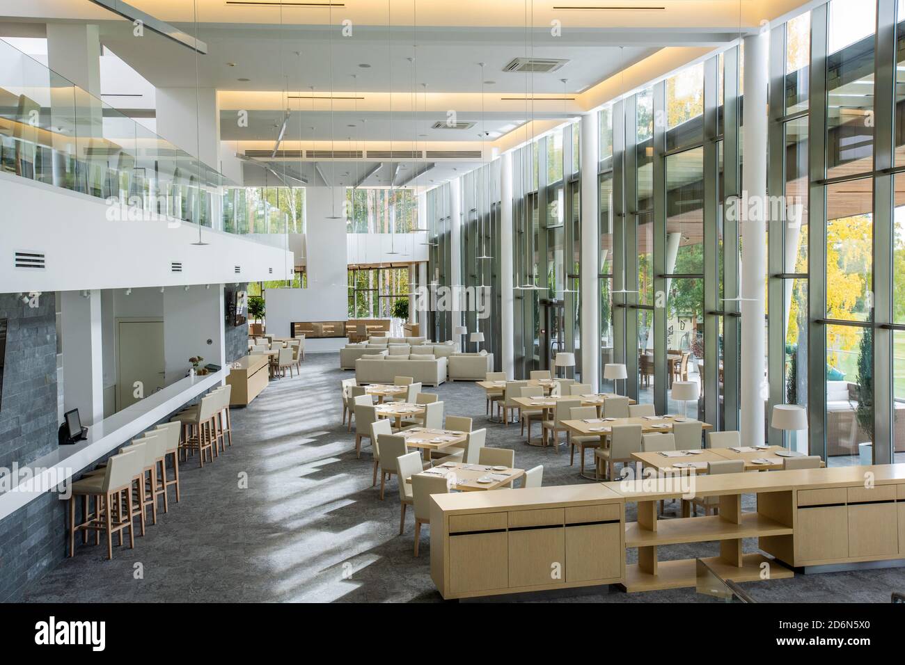 White chairs standing around square served tables and along bar counter ...