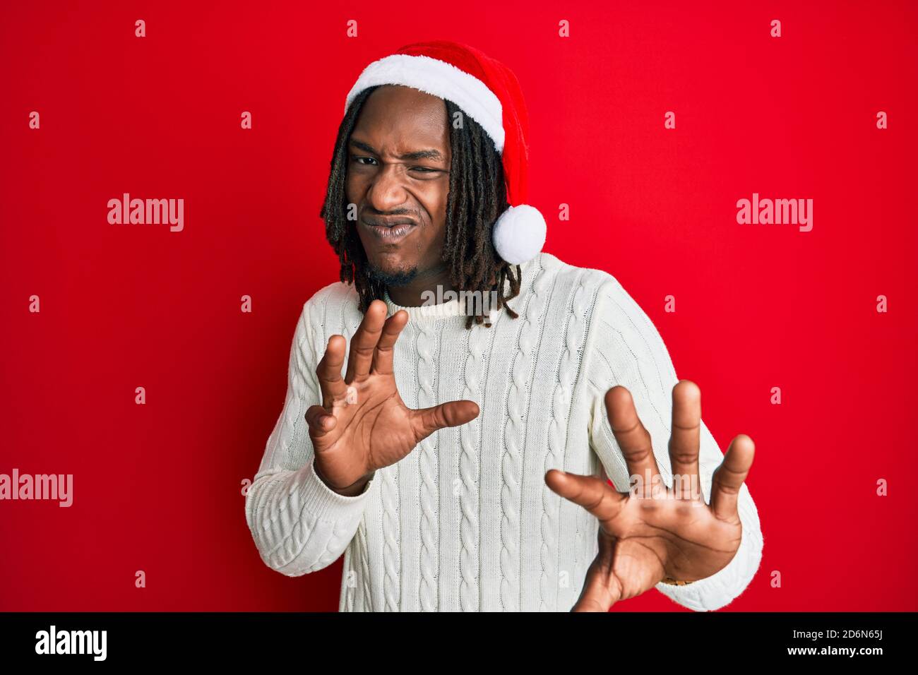 African american man with braids wearing christmas hat disgusted ...