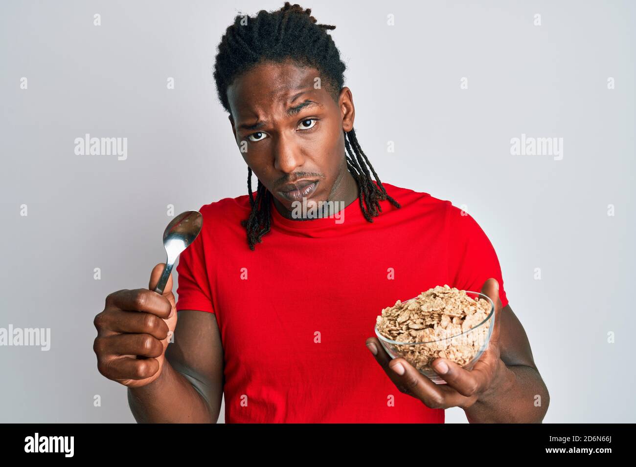 African american man with braids eating healthy whole grain celears ...