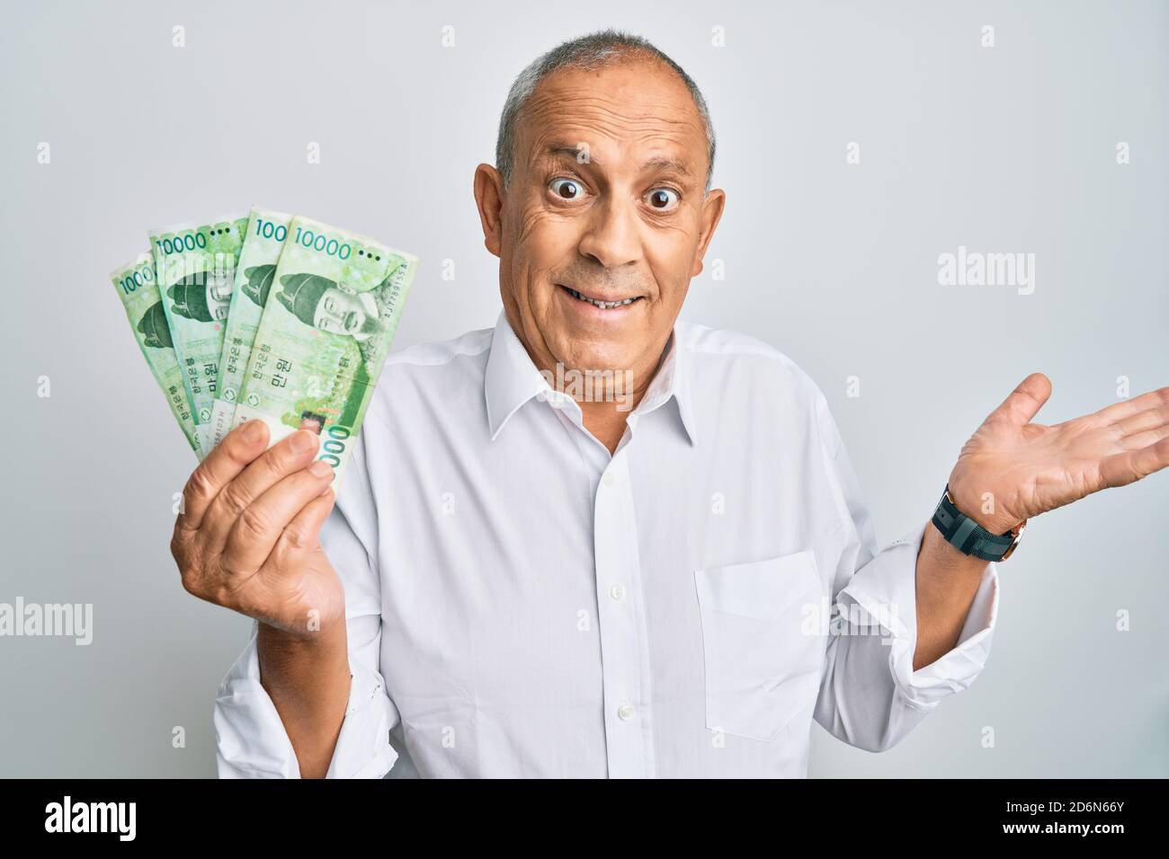 Handsome senior man holding 10000 south korean won banknotes ...