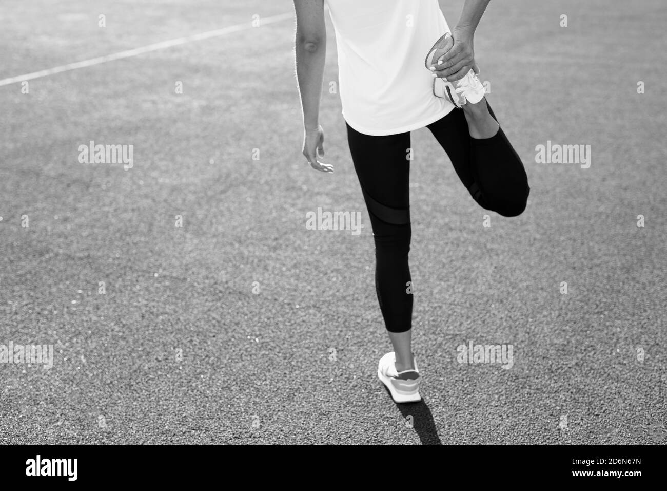 Back view of female runner stretching legs before workout Stock Photo ...