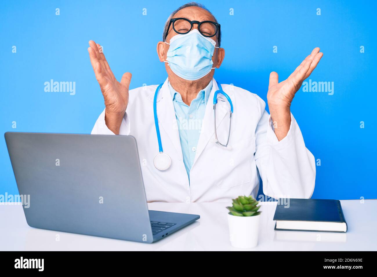 Senior handsome man with gray hair wearing doctor uniform and medical ...