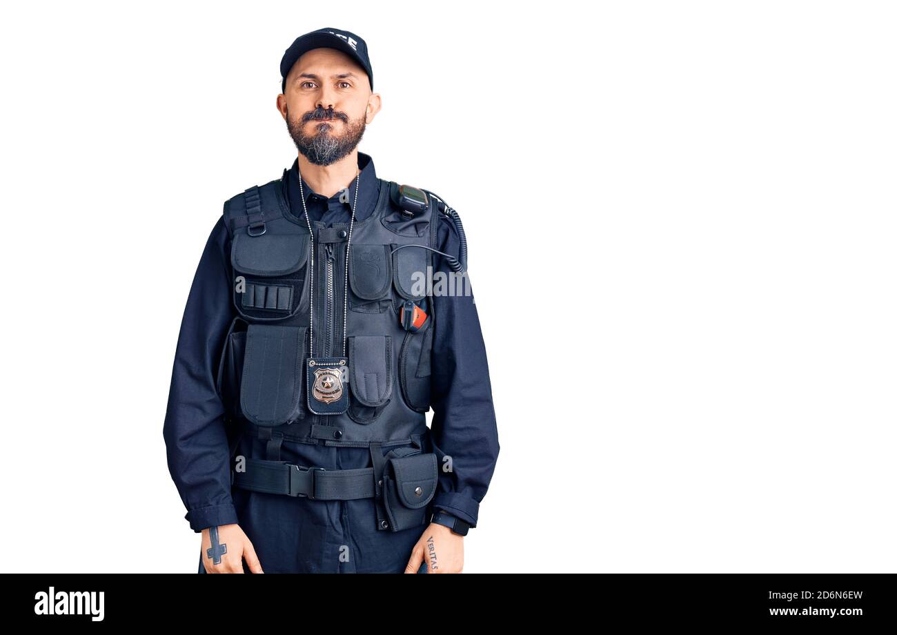 Young handsome man wearing police uniform puffing cheeks with funny ...
