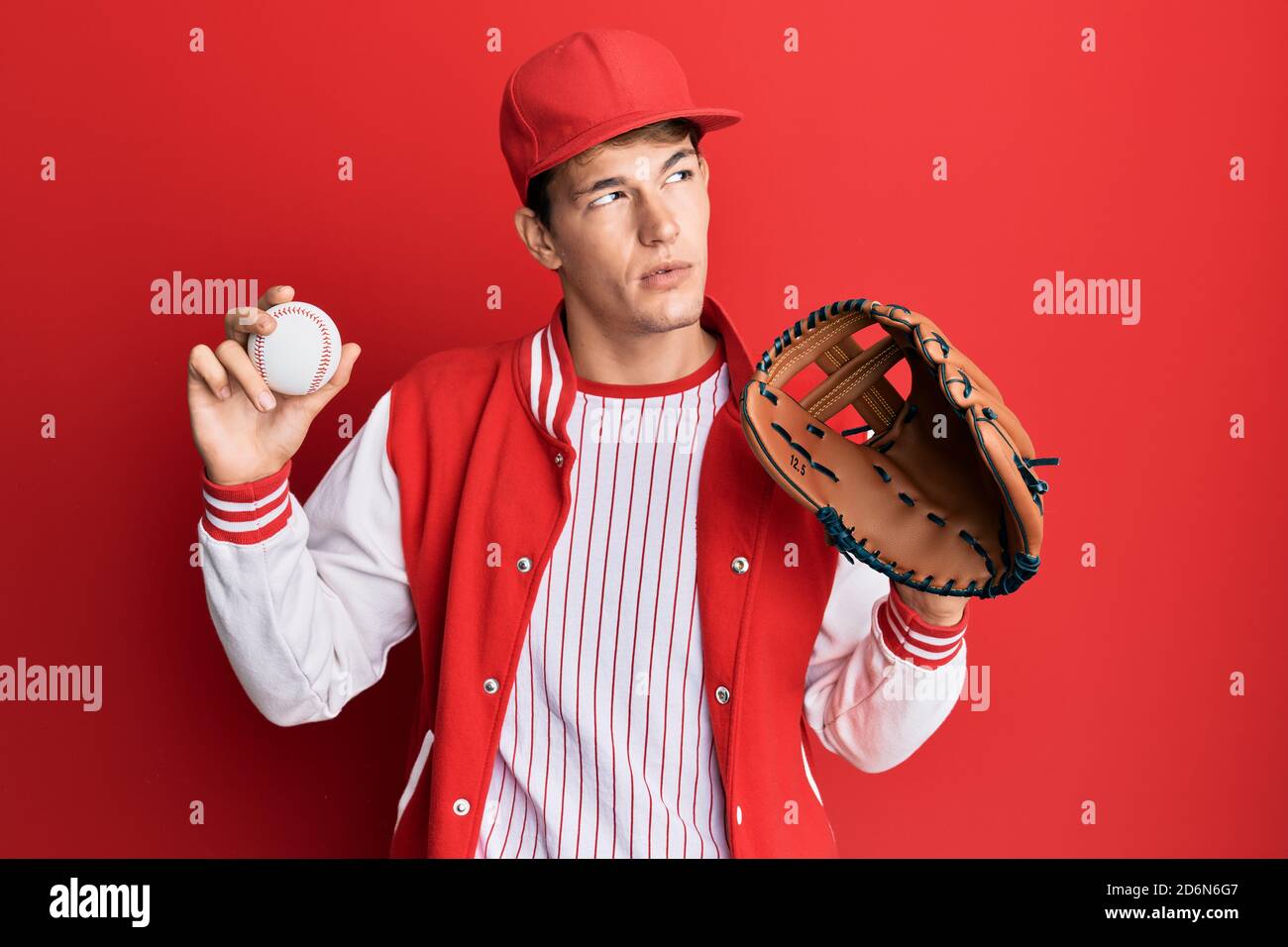 Handsome caucasian man wearing baseball uniform holding golve and ball ...