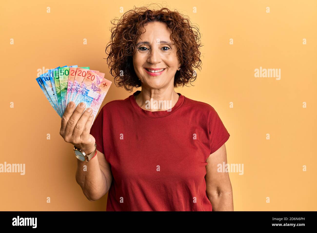 Beautiful middle age mature woman holding swiss franc banknotes looking ...