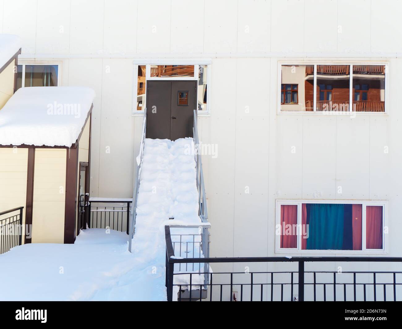 Back entrance to the building with snow-strewn steps and porch Stock ...