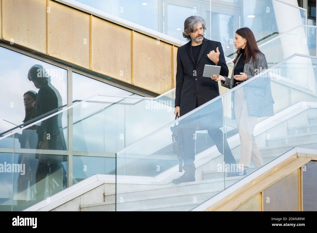 Mature businessman and his young colleague discussing working points on ...