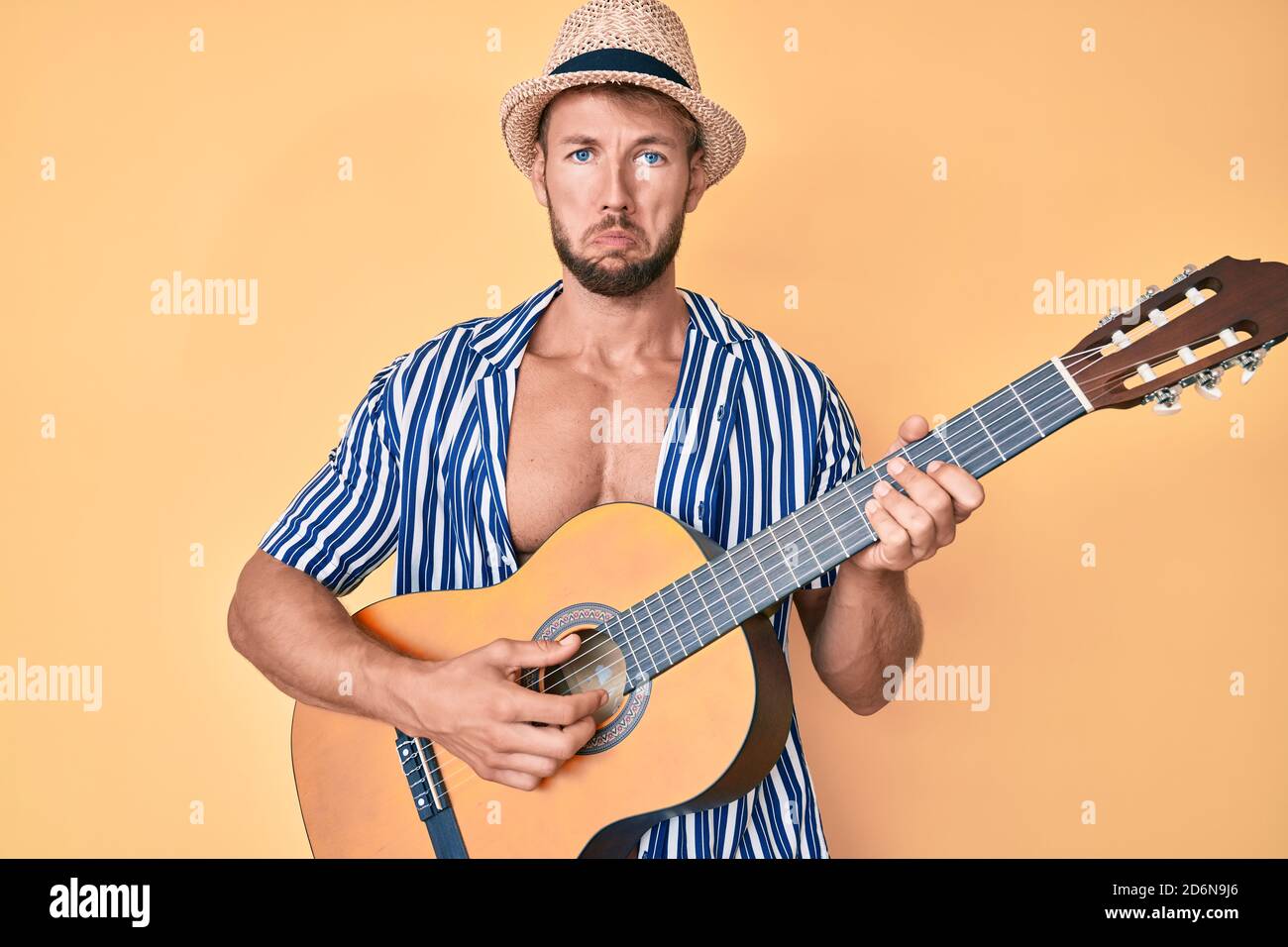 Young caucasian man wearing summer style playing classical guitar ...