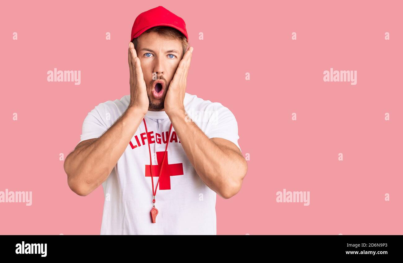 Young caucasian man wearing lifeguard t shirt holding whistle afraid ...