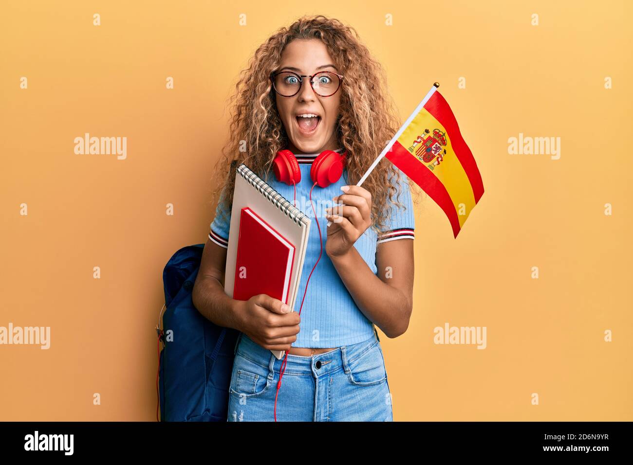 Beautiful caucasian teenager girl exchange student holding spanish flag ...