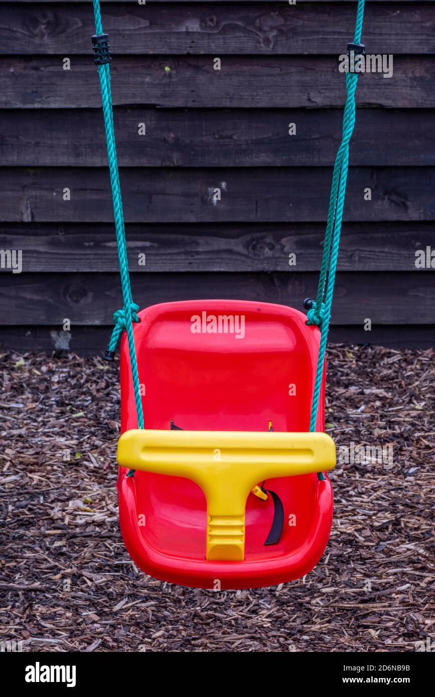 red plastic childs swing, childrens apparatus in playground, kiddies ...