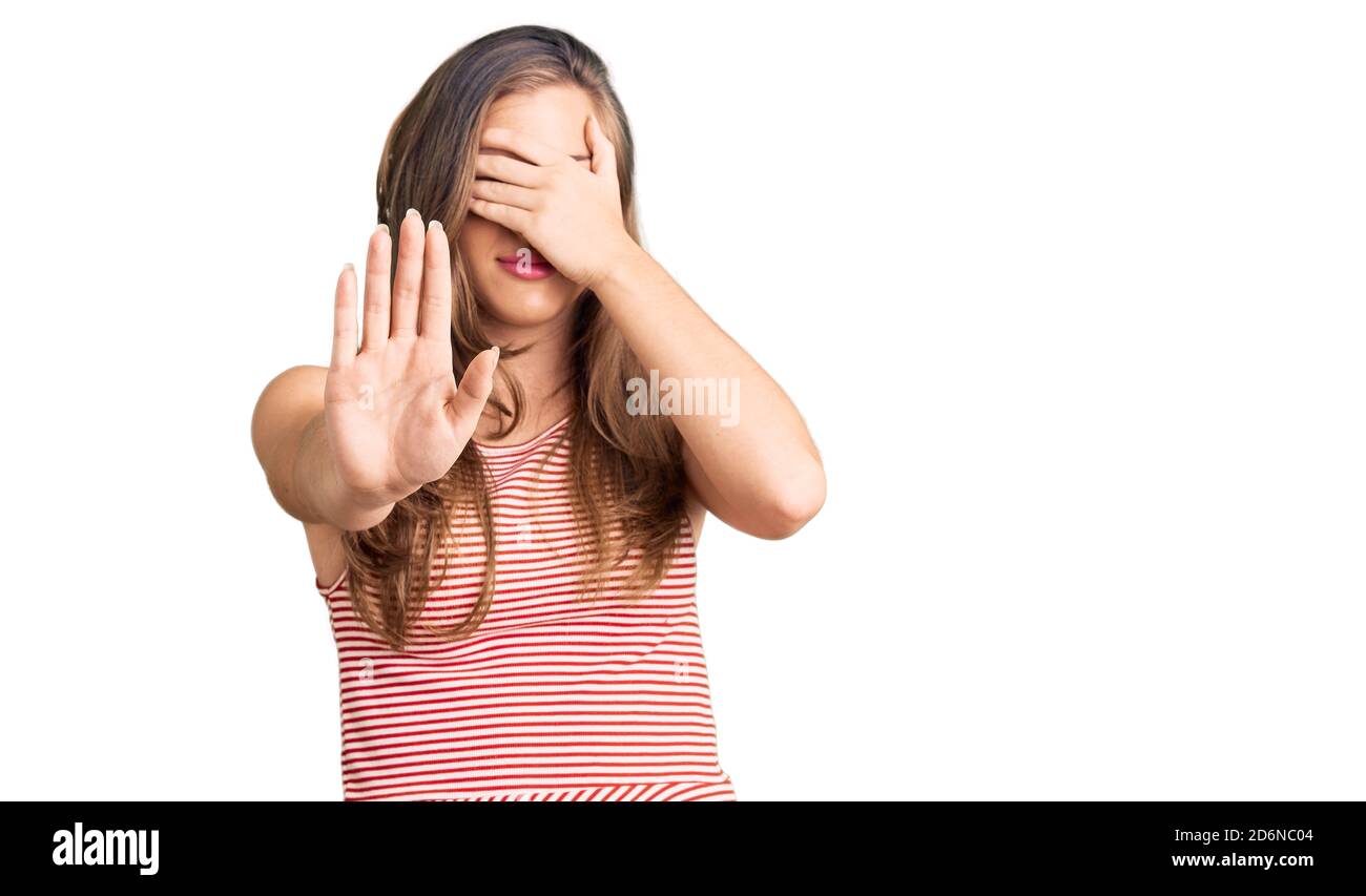 Beautiful caucasian young woman wearing casual clothes covering eyes ...