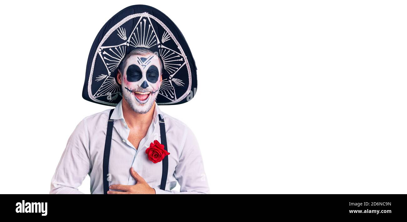 Man wearing day of the dead costume over background smiling and ...