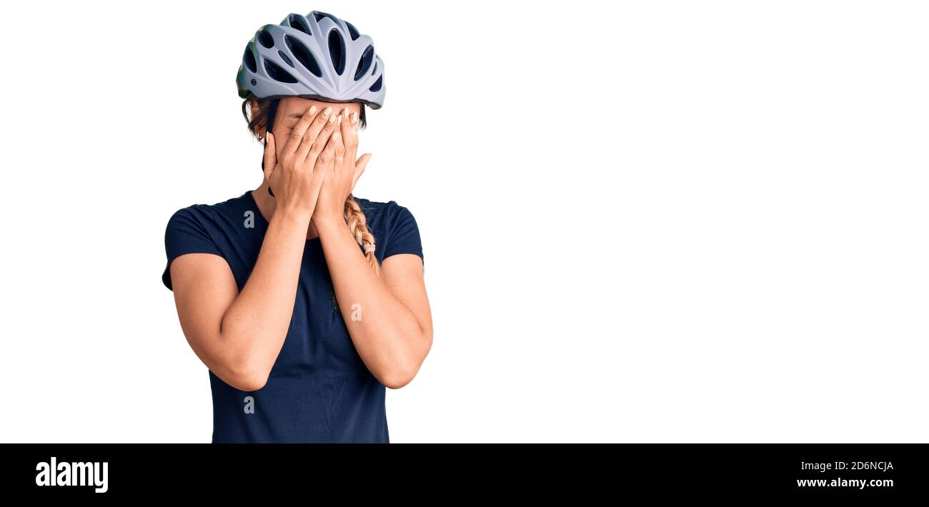 Beautiful caucasian woman wearing bike helmet with sad expression ...