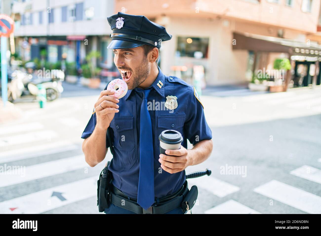Young handsome hispanic policeman wearing police uniform smiling happy ...