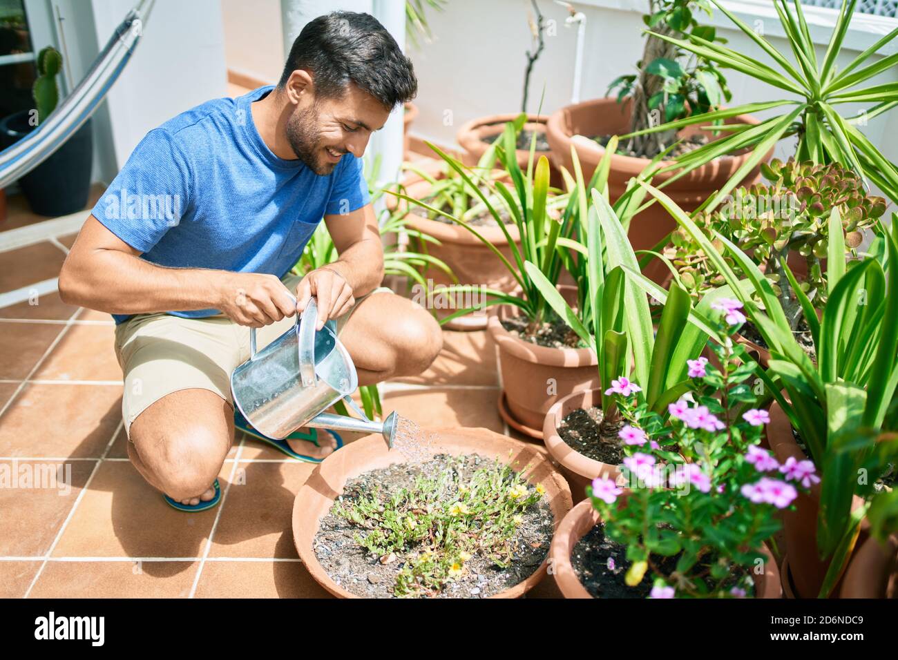 Young man using watering can hi-res stock photography and images - Alamy
