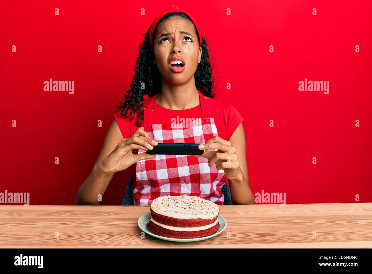 Young african american girl wearing baker apron making carrot cake ...