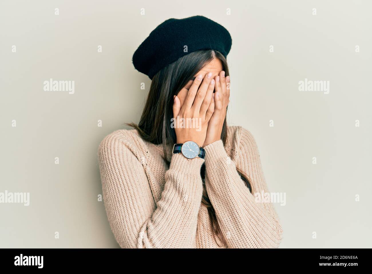 Young brunette woman wearing french look with beret with sad expression ...