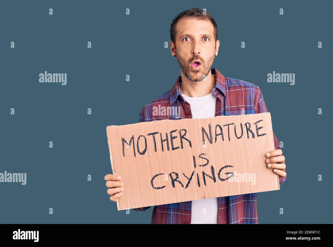 Young handsome man holding mother nature is crying protest cardboard ...