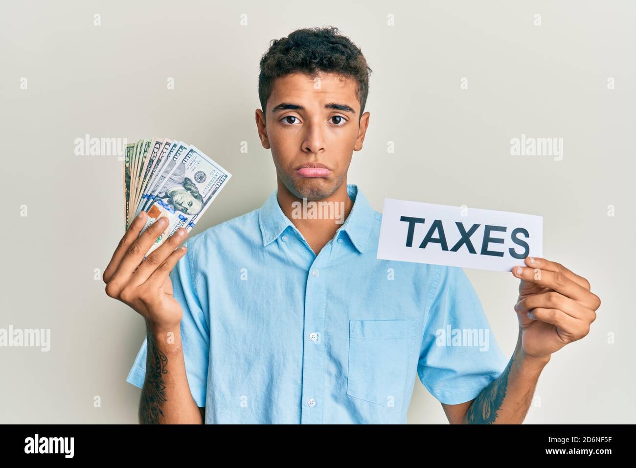 Young handsome african american man holding dollars and taxes paper ...