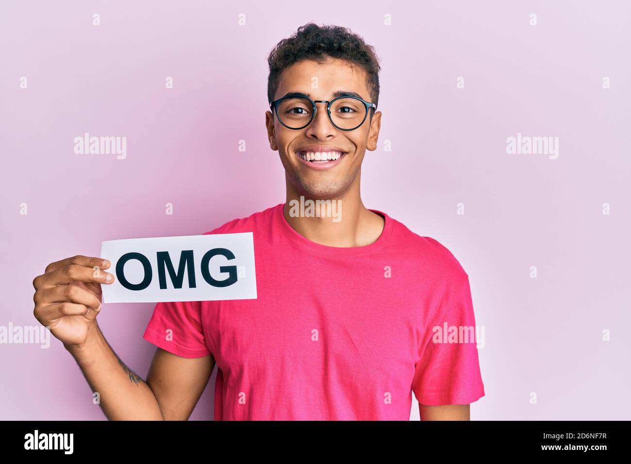 Young handsome african american man holding omg message paper looking ...