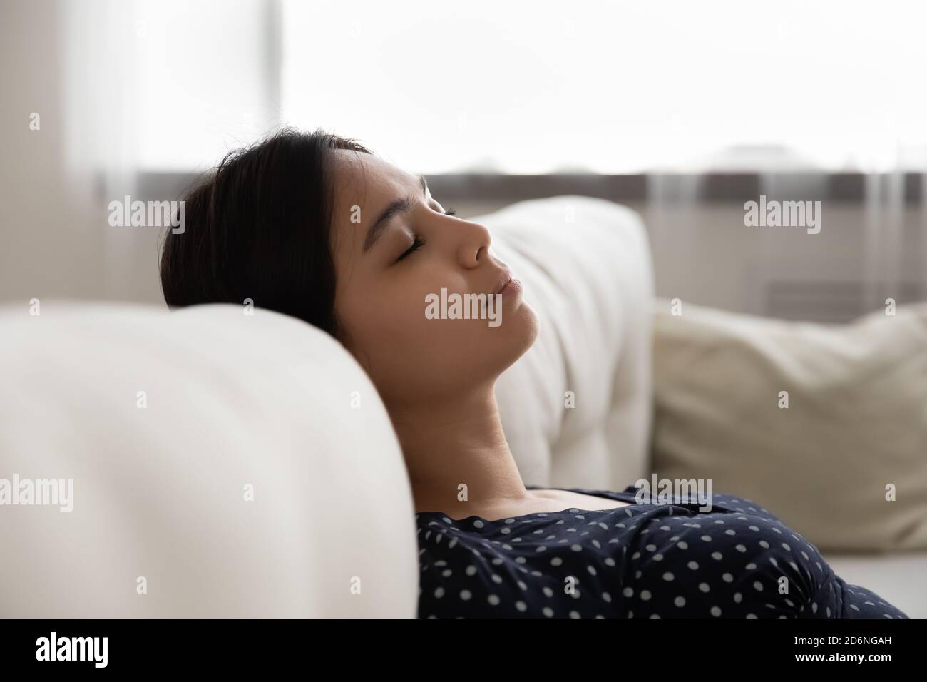 Calm ethnic woman fall asleep on cozy couch Stock Photo - Alamy