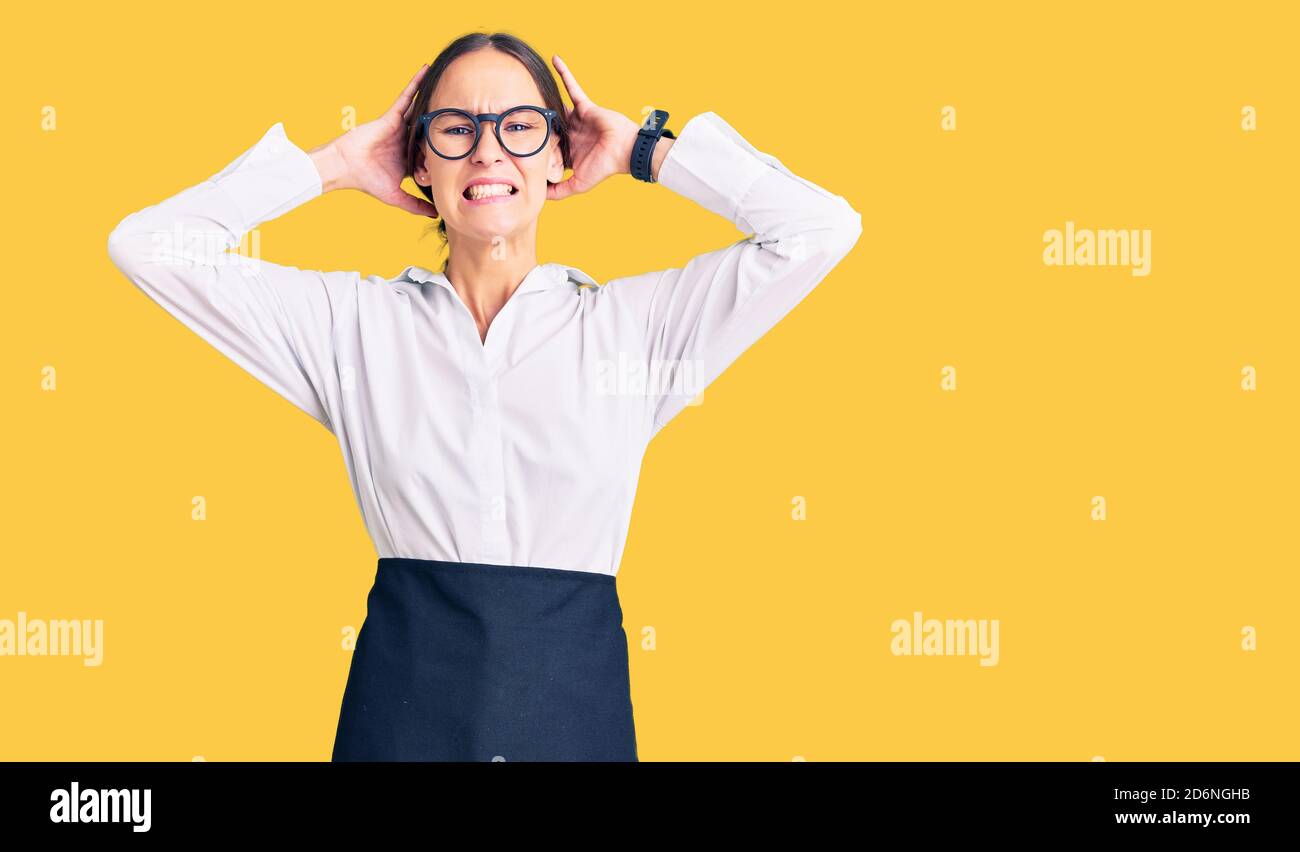 Beautiful brunette young woman wearing professional waitress apron ...