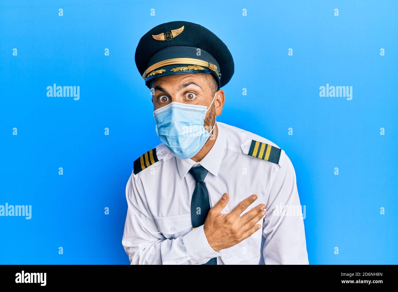 Handsome man with beard wearing airplane pilot uniform wearing safety ...