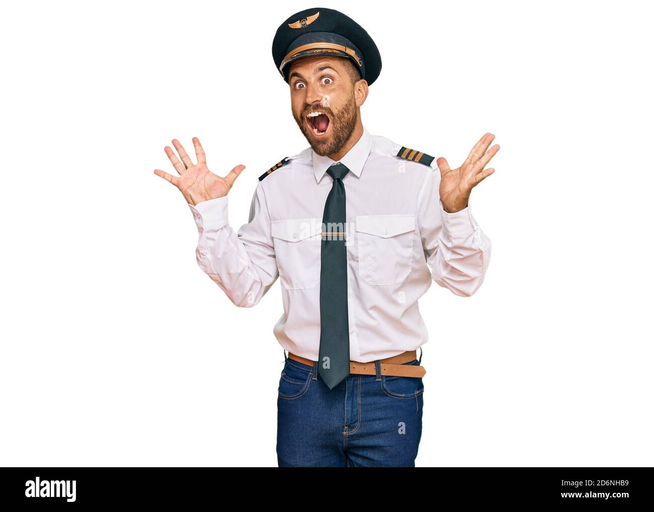 Handsome man with beard wearing airplane pilot uniform celebrating ...