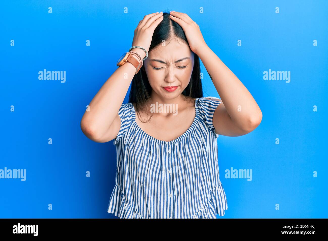 Young chinese woman wearing casual striped t-shirt suffering from ...