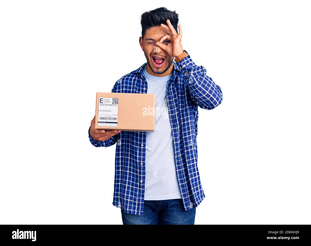 Handsome latin american young man holding delivery package smiling ...