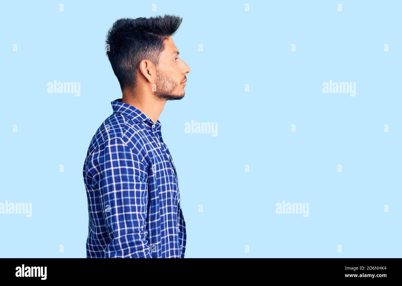 Handsome latin american young man wearing casual shirt looking to side ...