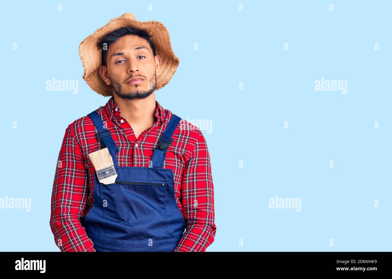 Handsome latin american young man weaing handyman uniform looking ...