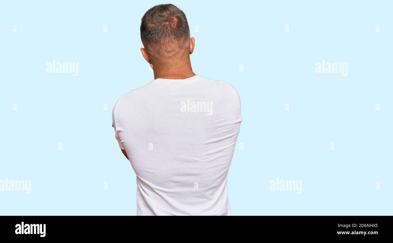 Handsome muscle man wearing casual white tshirt hugging oneself happy ...