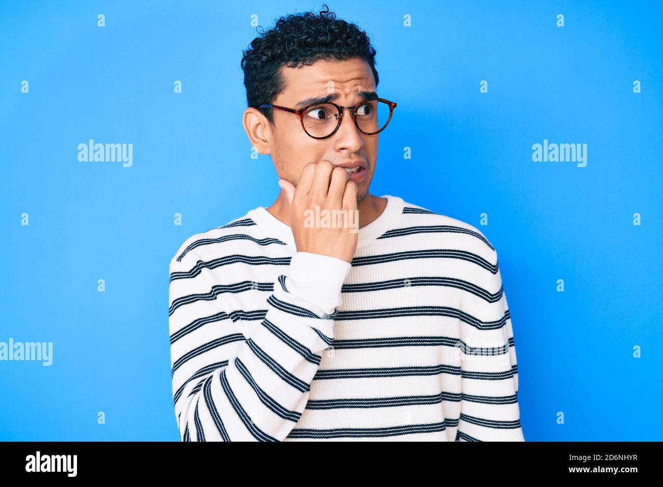 Young handsome hispanic man wearing casual sweater and glasses looking ...