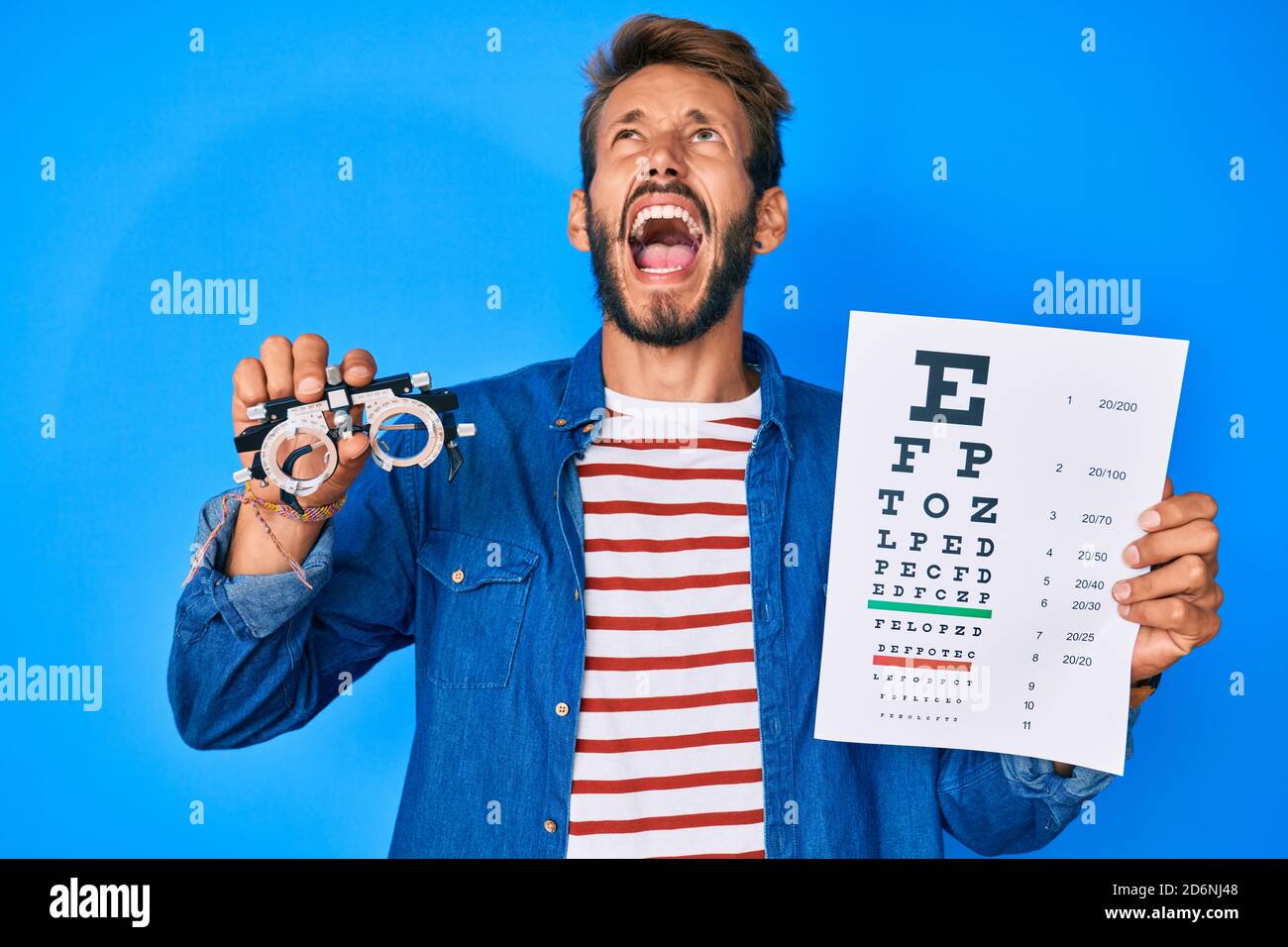 Handsome caucasian man with beard holding optometry glasses and ...