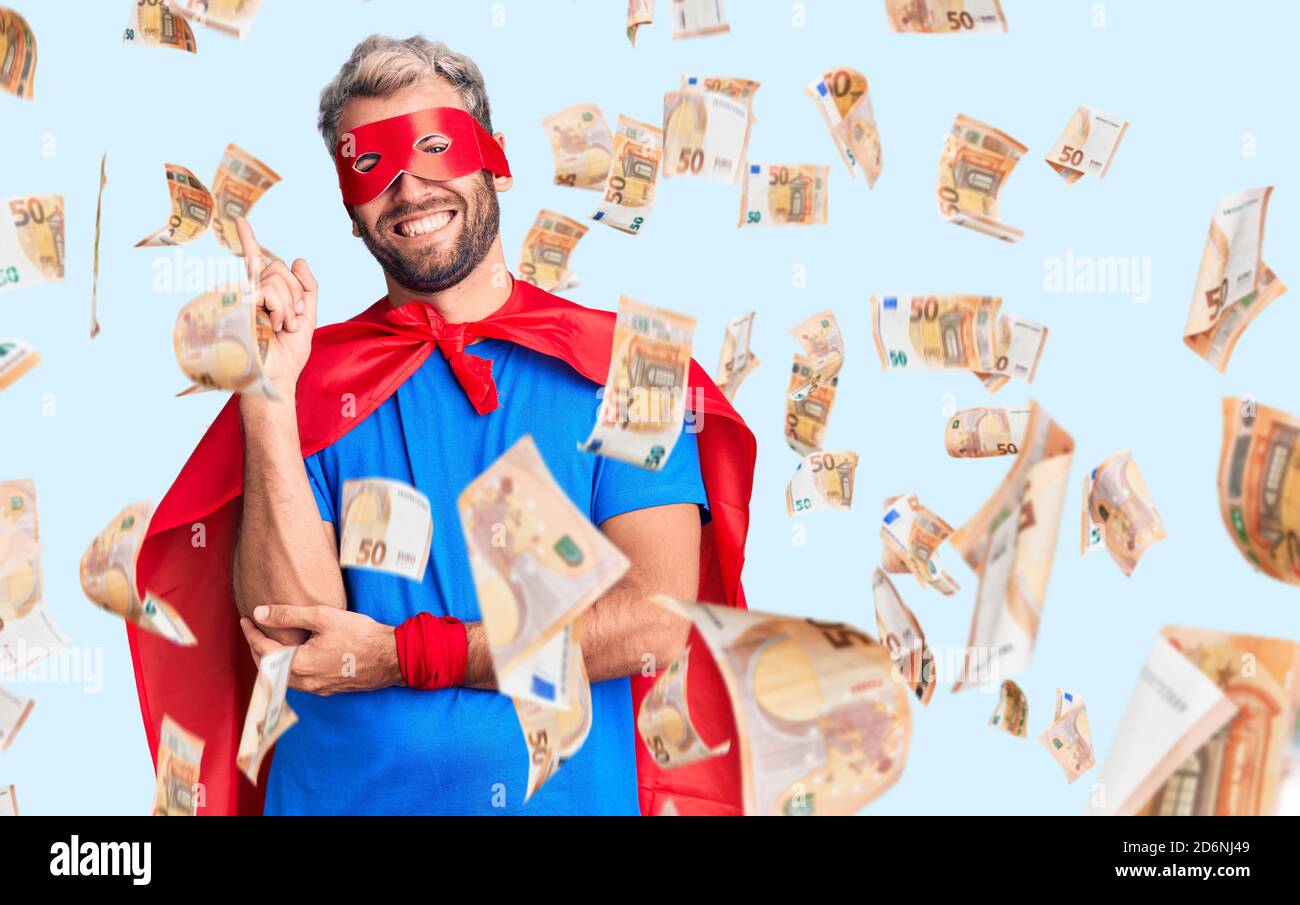 Young blond man wearing super hero custome with a big smile on face ...