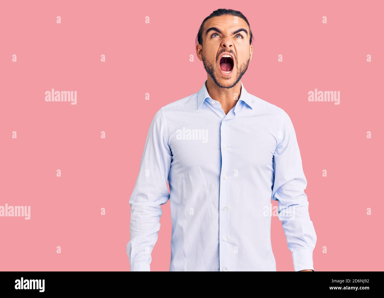 Young handsome man wearing business clothes angry and mad screaming ...