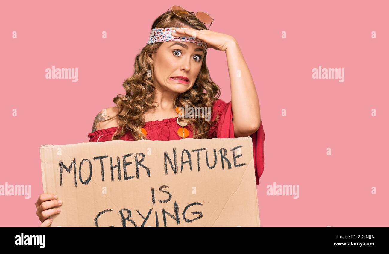 Young blonde girl wearing hippie style holding mother nature is crying ...