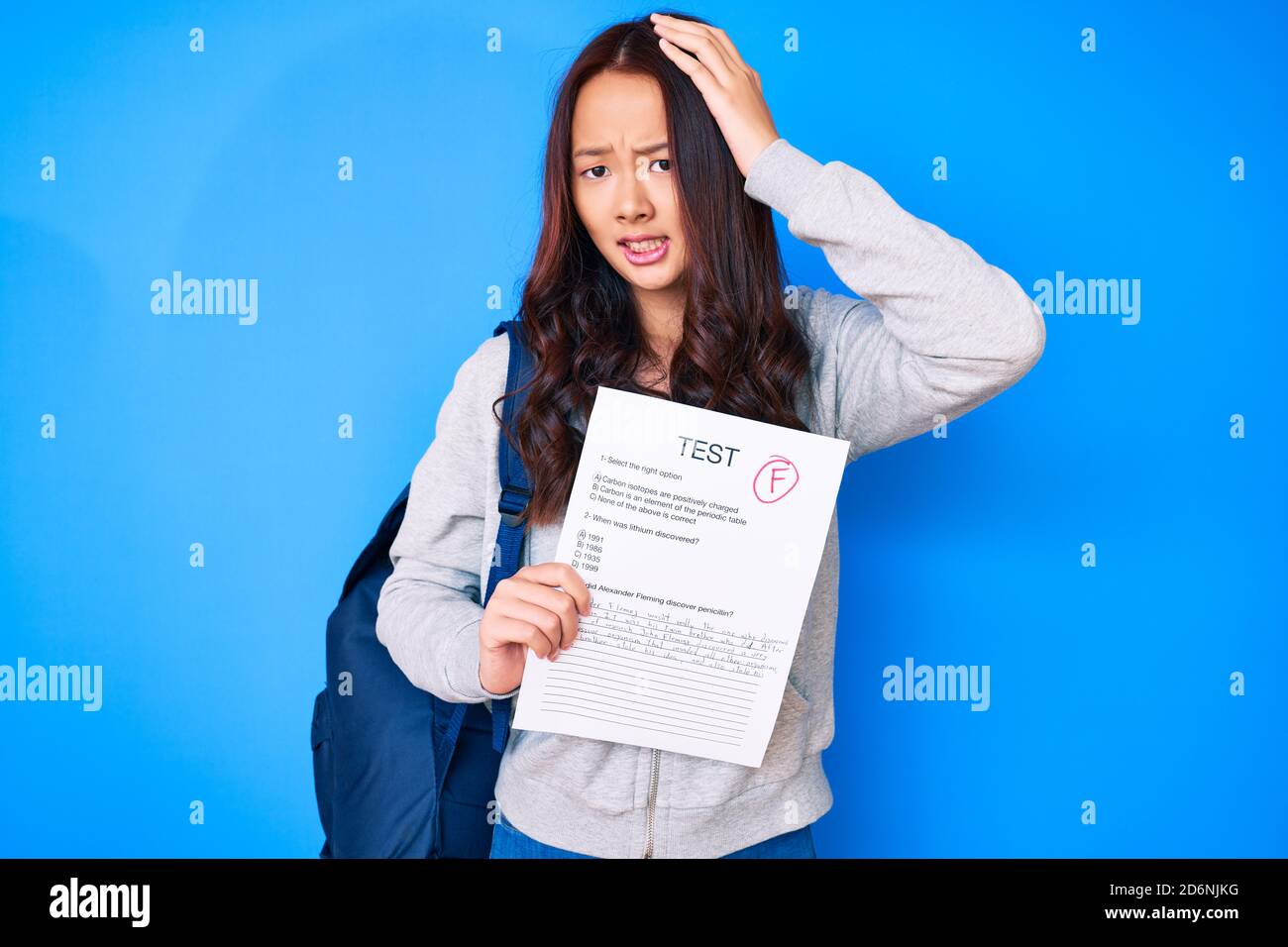Young beautiful chinese girl showing a failed exam stressed and ...