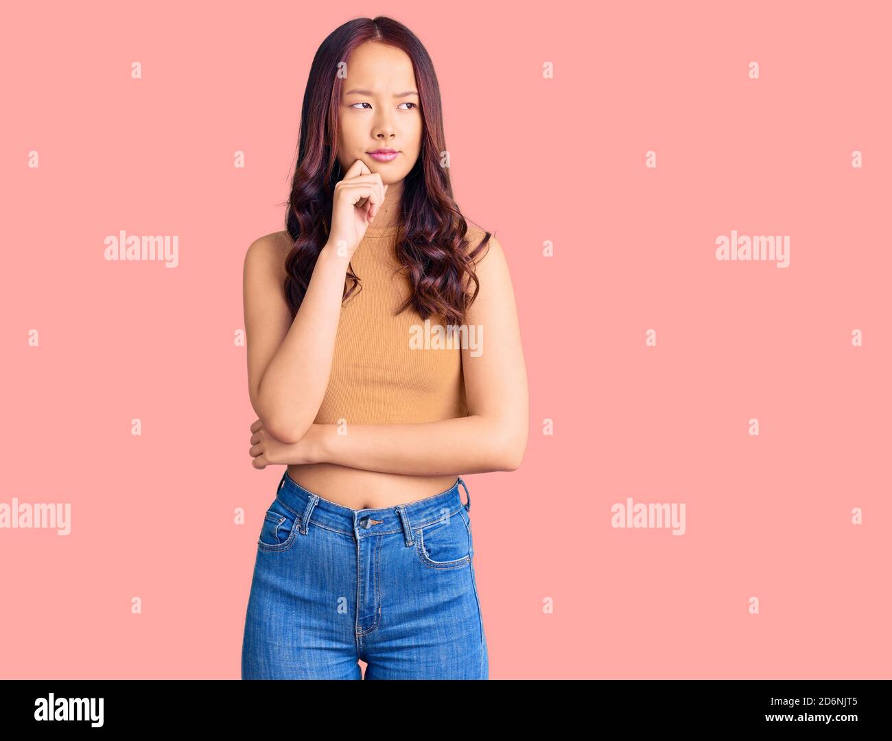 Young beautiful chinese girl wearing casual clothes serious face ...