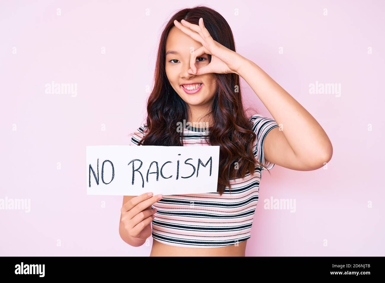 Young beautiful chinese girl holding no racism banner smiling happy ...
