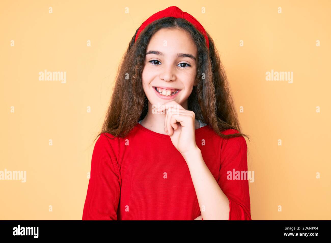 Cute hispanic child girl wearing casual clothes and diadem looking ...
