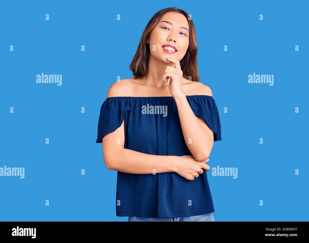 Young beautiful chinese girl wearing casual clothes looking confident at the camera with smile ...