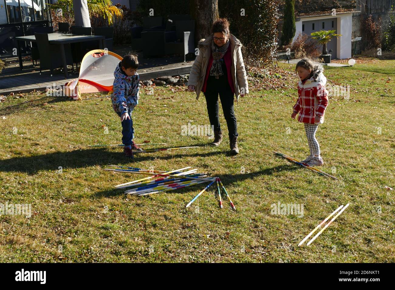 Grandmother playing giant Mikado with her grandchildren Stock Photo - Alamy
