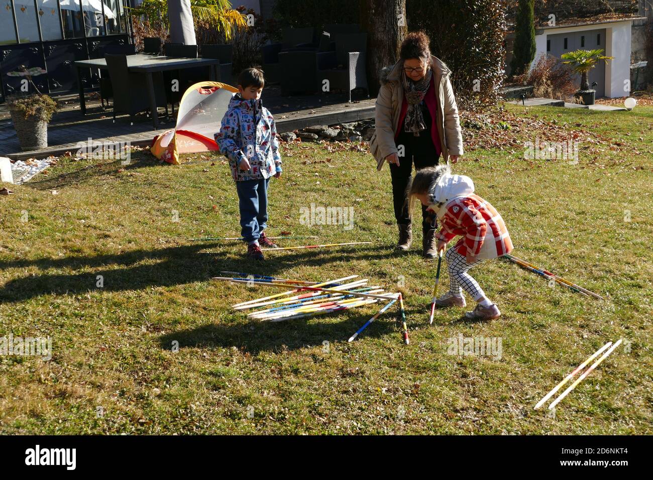 Grandmother playing giant Mikado with her grandchildren Stock Photo - Alamy