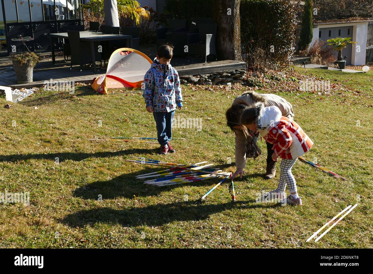 Grandmother playing giant Mikado with her grandchildren Stock Photo - Alamy